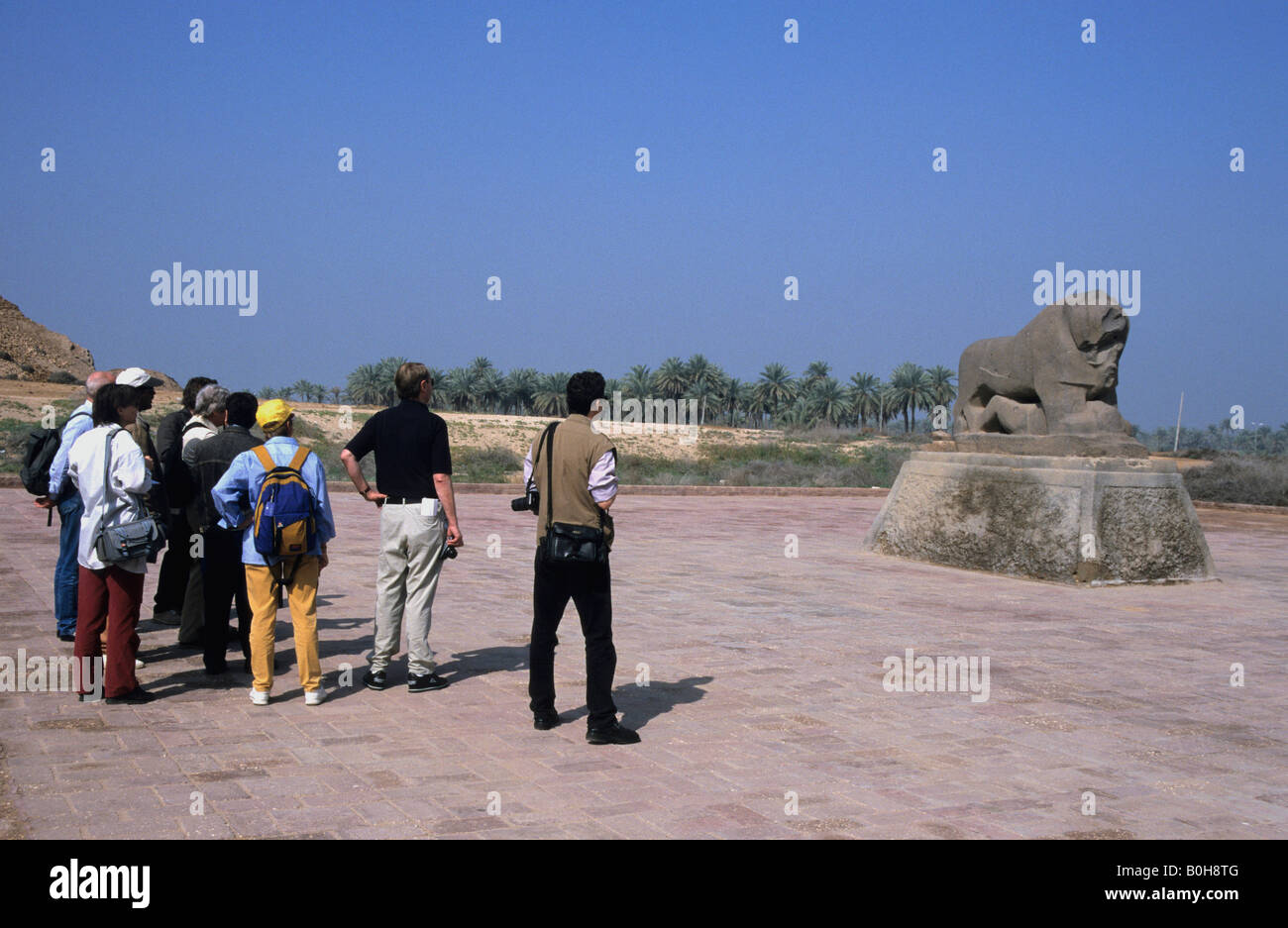 Tourist group looking at the famous lion statue in Babylon, Iraq ...