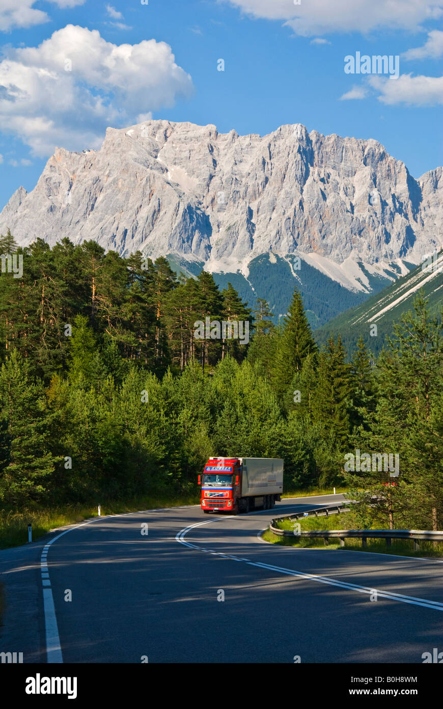 Red truck climbing the Fernpass mountain pass road, Mt. Zugspitze at ...