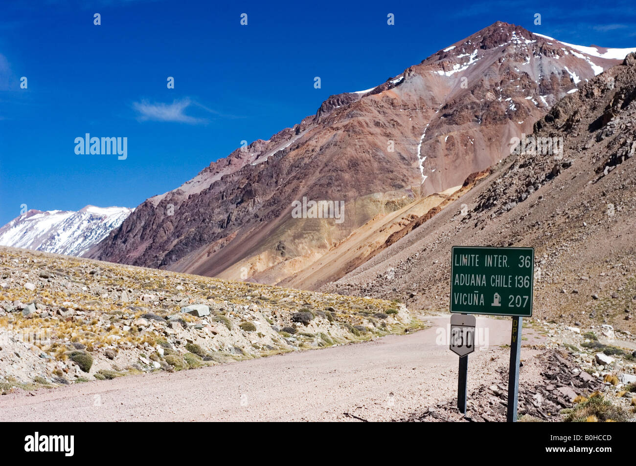 Road sign on dirt road of route 150 high in arid snow peaked mountains ...