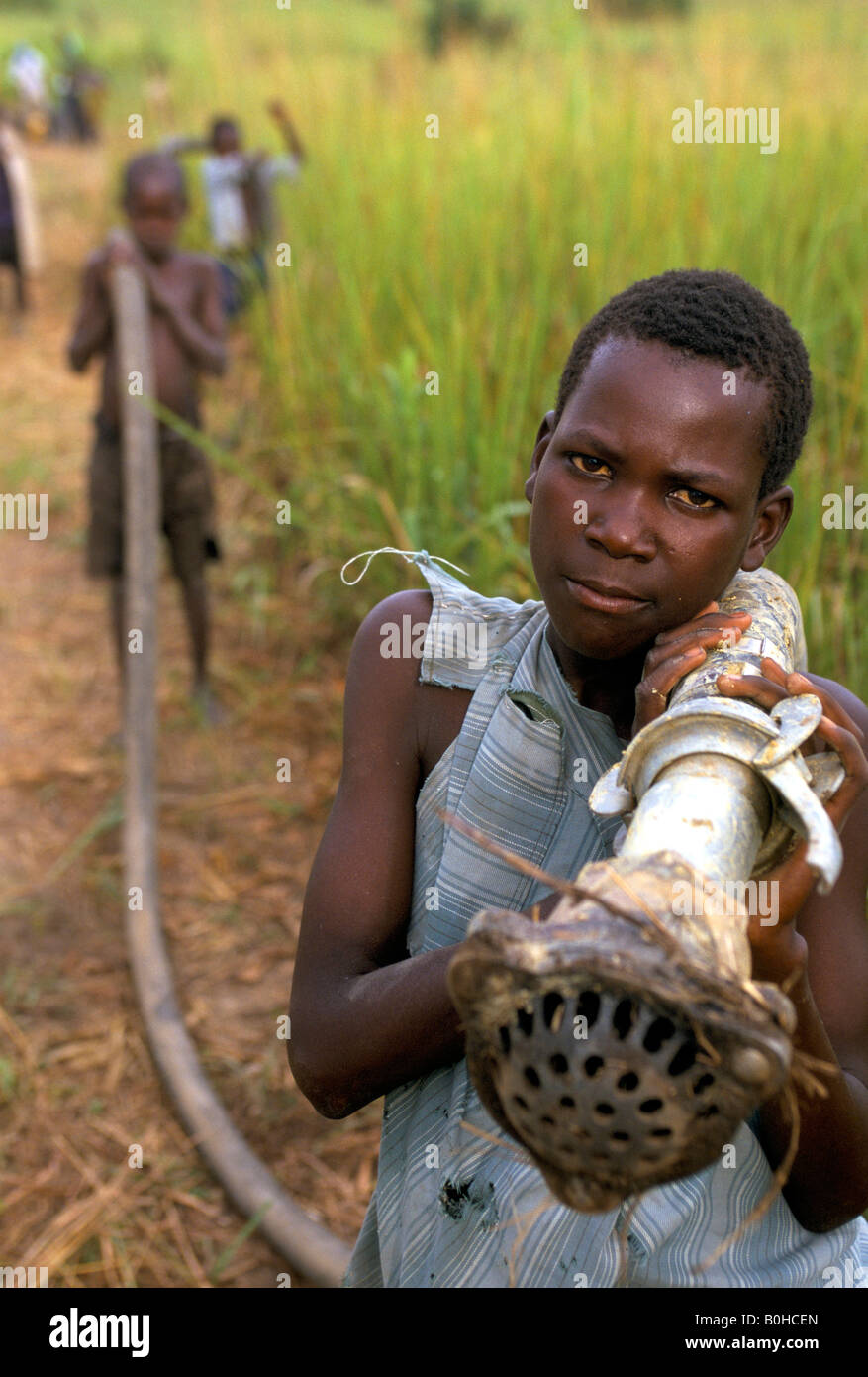 A boy helping to dig a new well for a WaterAid project, Soroti, Uganda ...