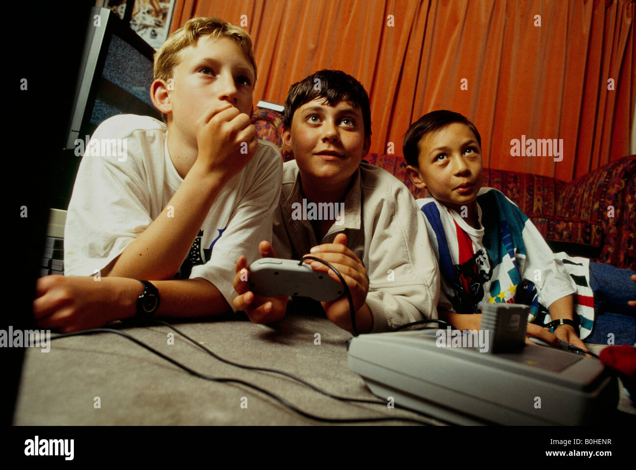Three boys playing a computer game at home, Oxfordshire, England Stock ...