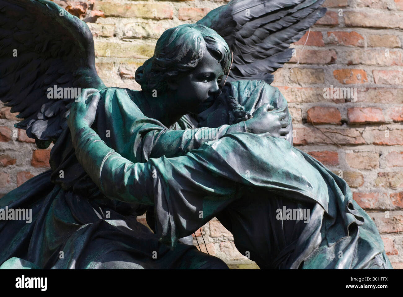 Sculpture of an angel embracing a woman, Alter Suedfriedhof, old ...