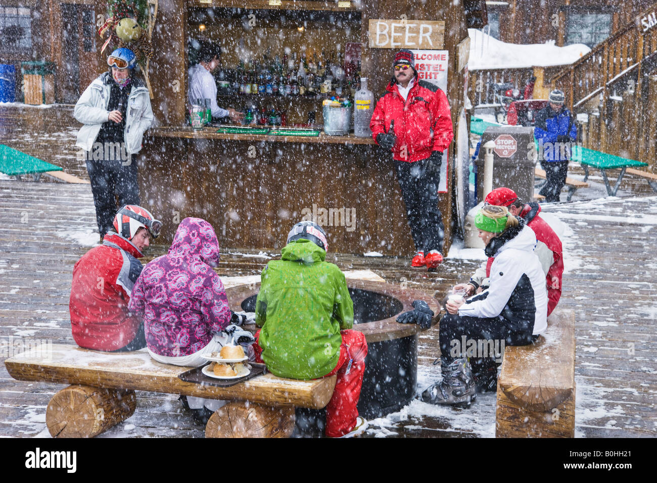 Skiers drinking around a fire in the snow at Telluride Ski Resort ...