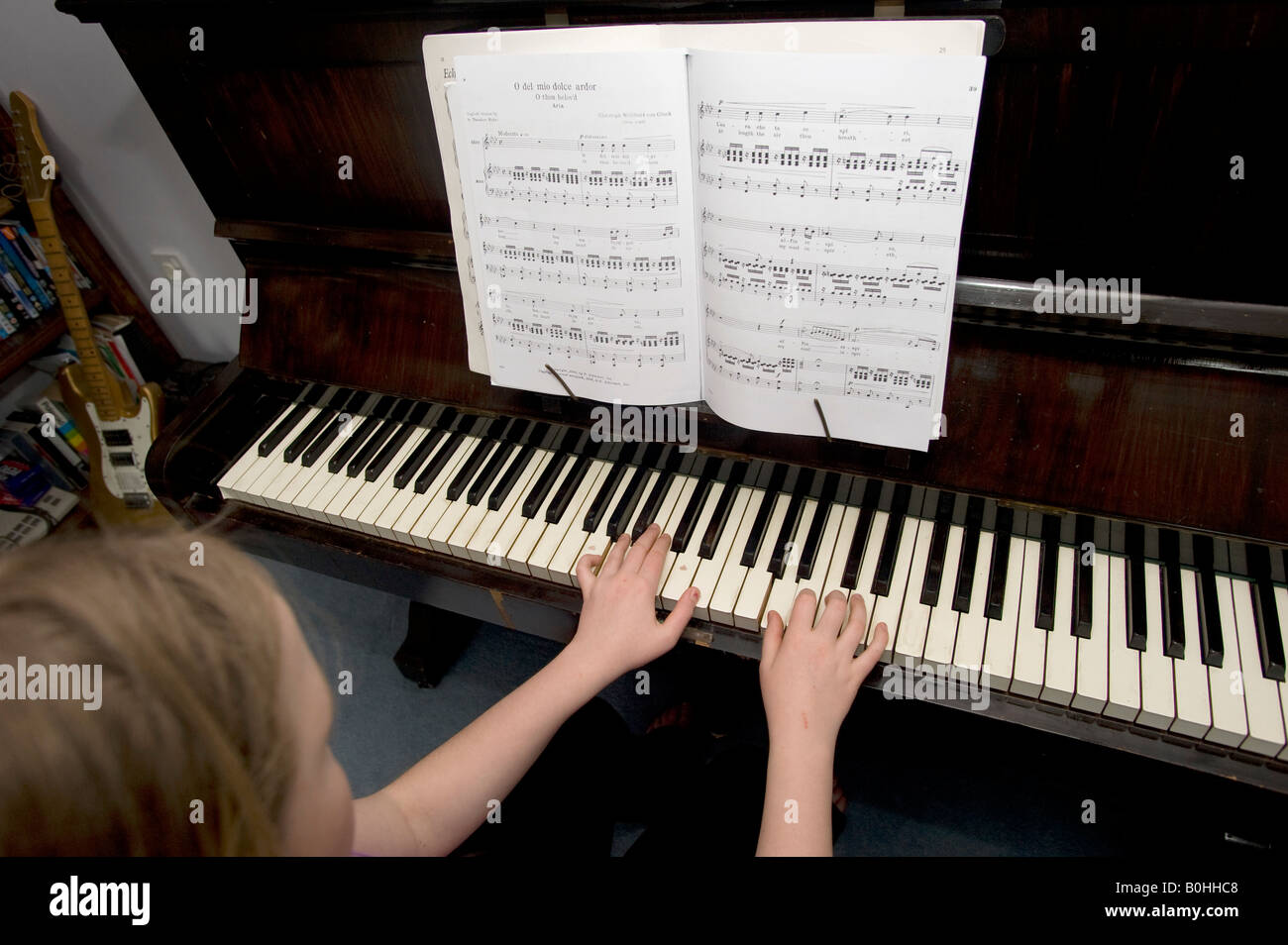 A child practices the piano as her musical instrument at home Taking ...
