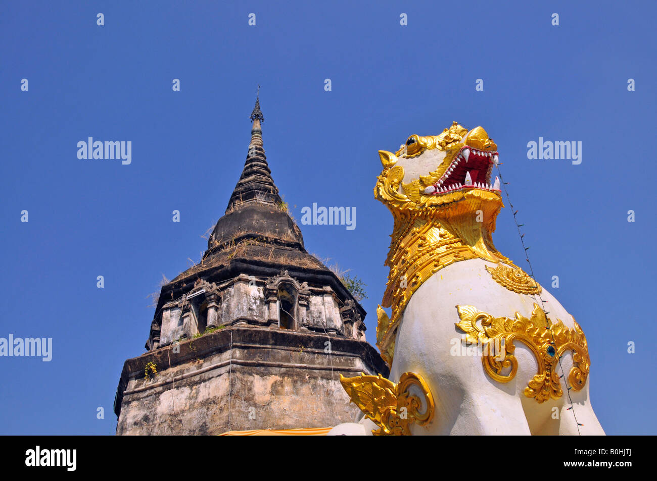 Gilt statue in front of an old stupa, Wat Yaang Kuong Temple, Chiang ...
