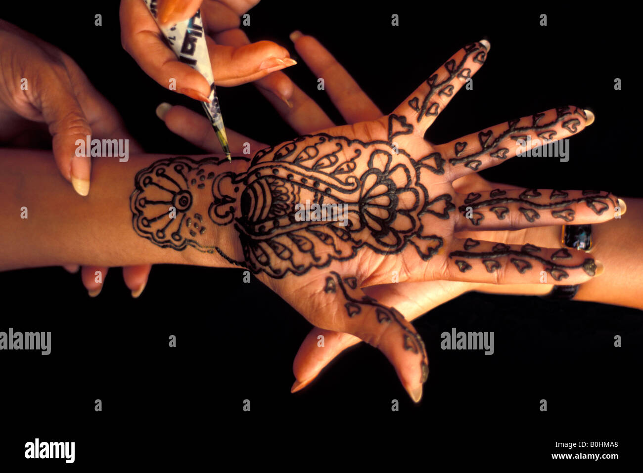 A close up of a henna decoration being applied to a hand, United Arab ...