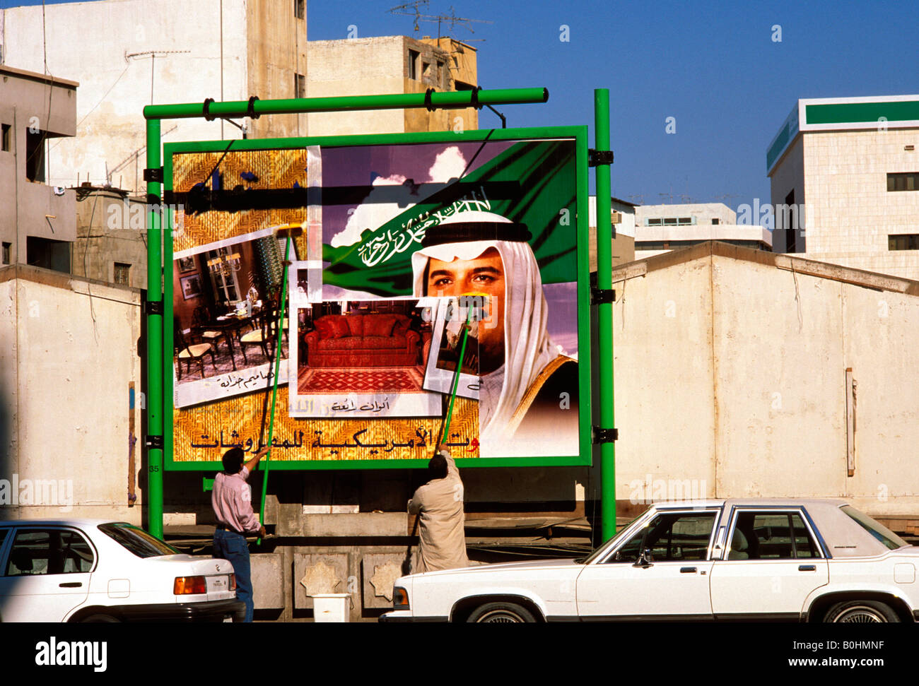 Men putting up an advertising poster, Saudi Arabia Stock Photo - Alamy