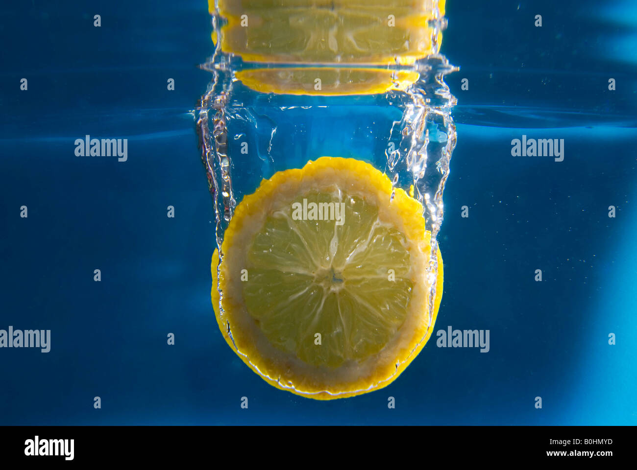 Slice of lemon falling into water Stock Photo - Alamy
