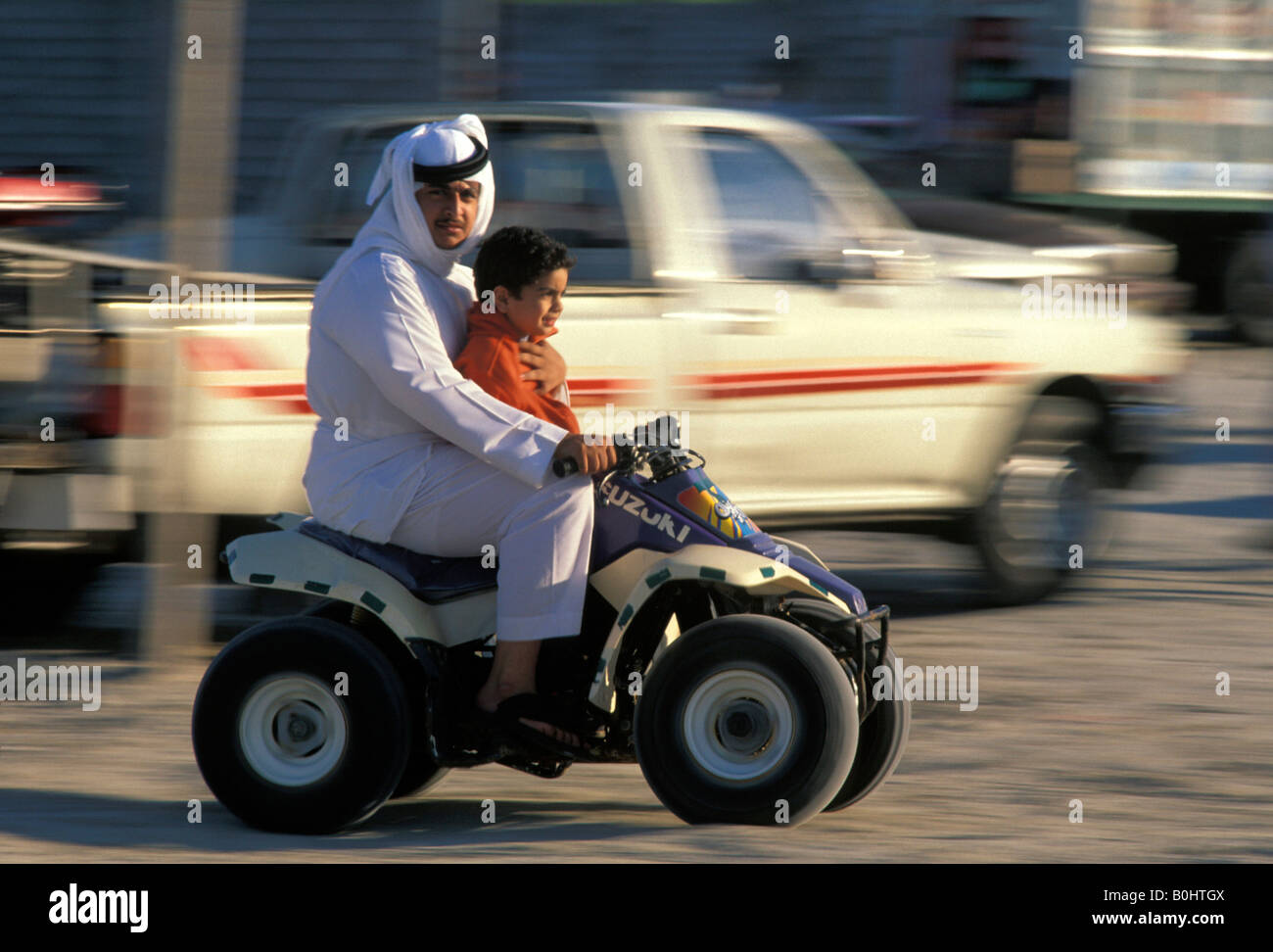 A man and child on a quad bike, Saudi Arabia Stock Photo - Alamy