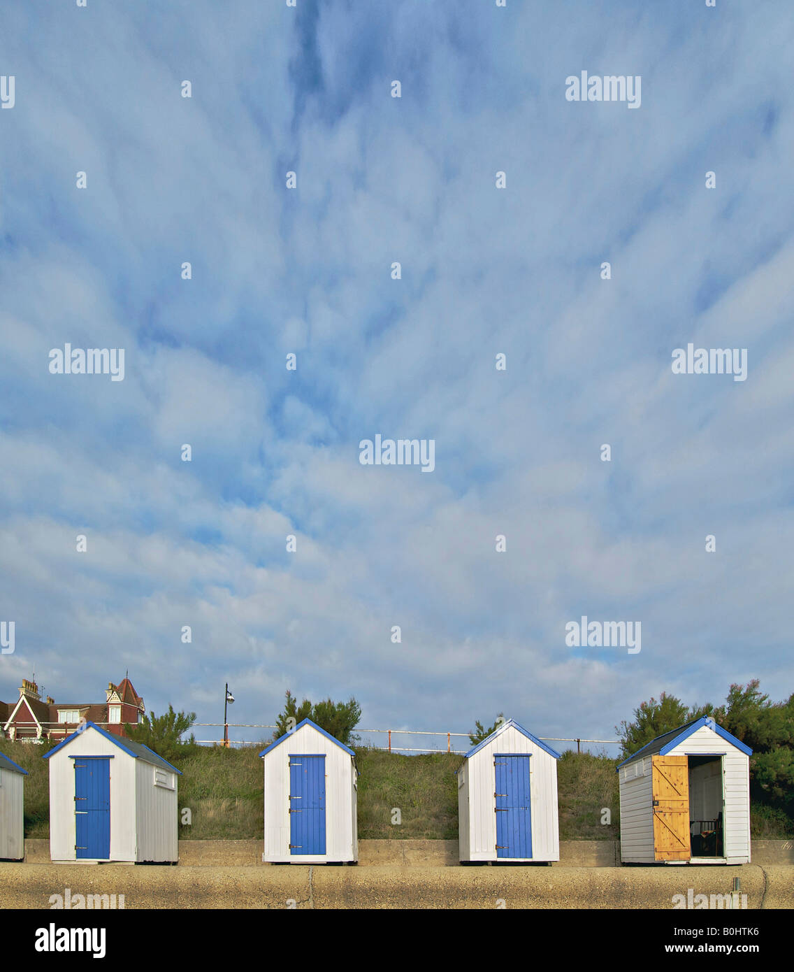 Four beach huts in a row, one door open Stock Photo - Alamy