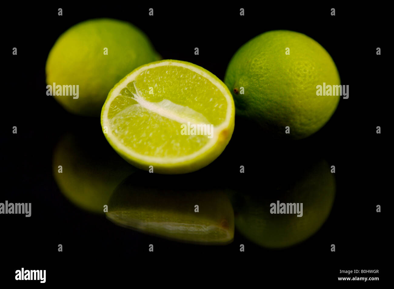 Limes isolated against a black background Stock Photo - Alamy