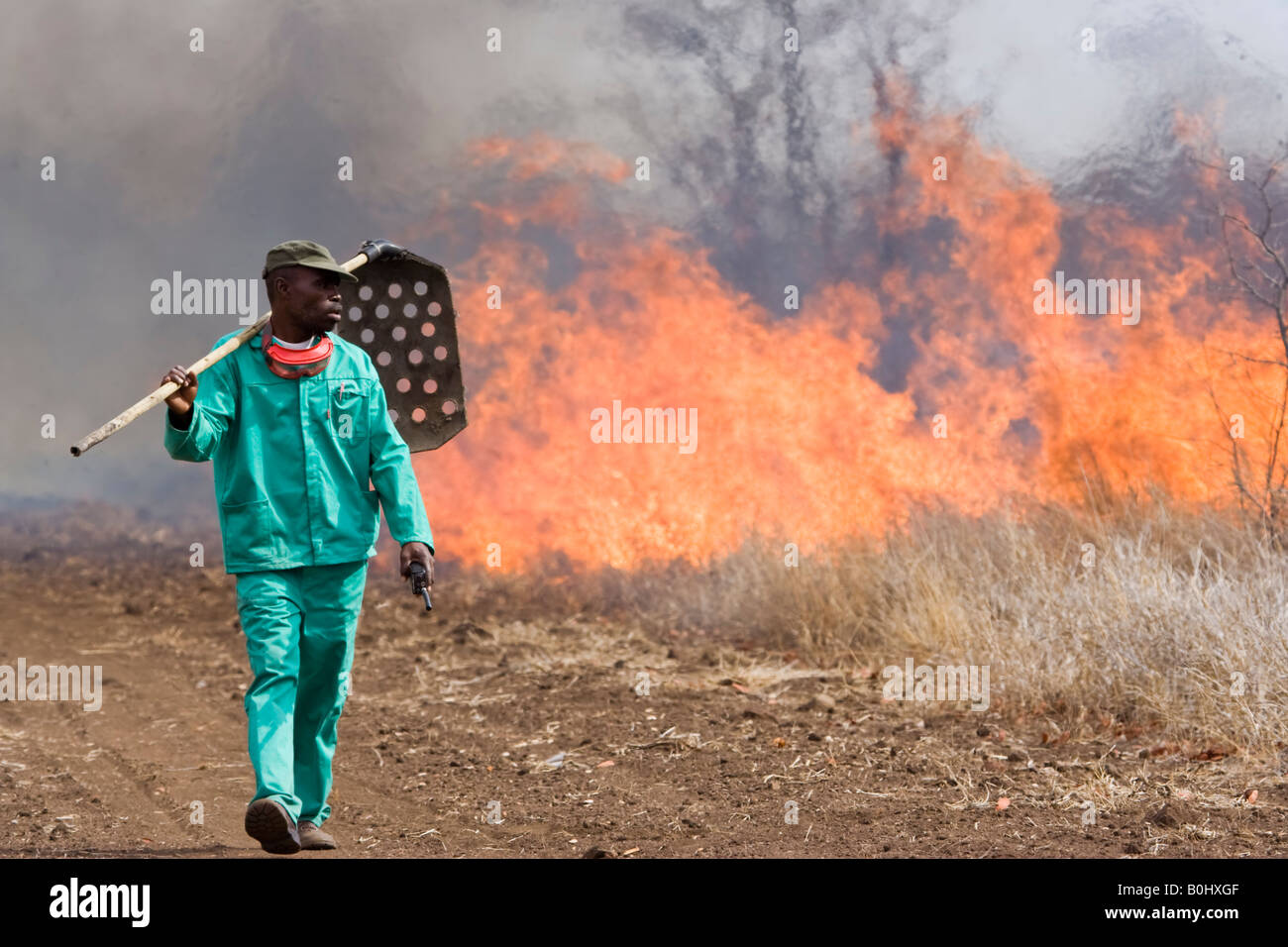 A fire worker watches carefully to make sure the fire doesnt jump the ...