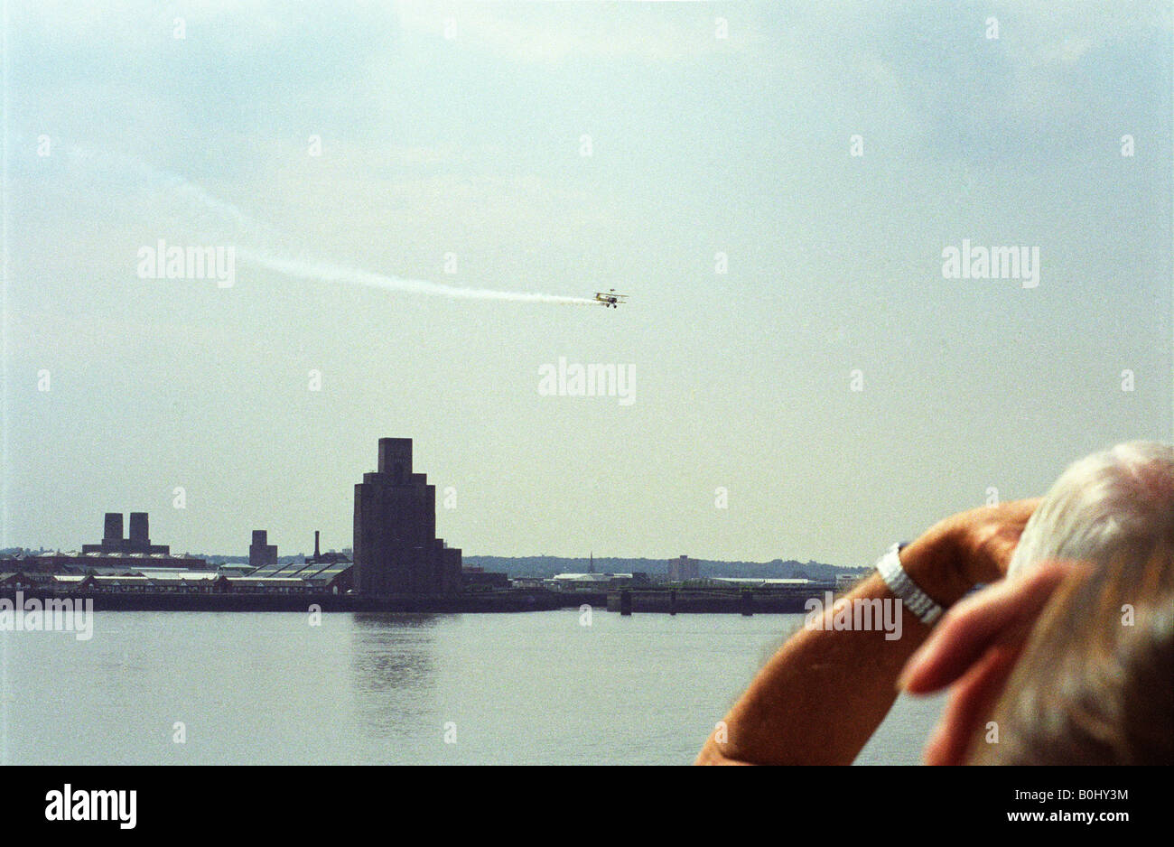 Two people watching bi plane an old style of airoplane performing ...