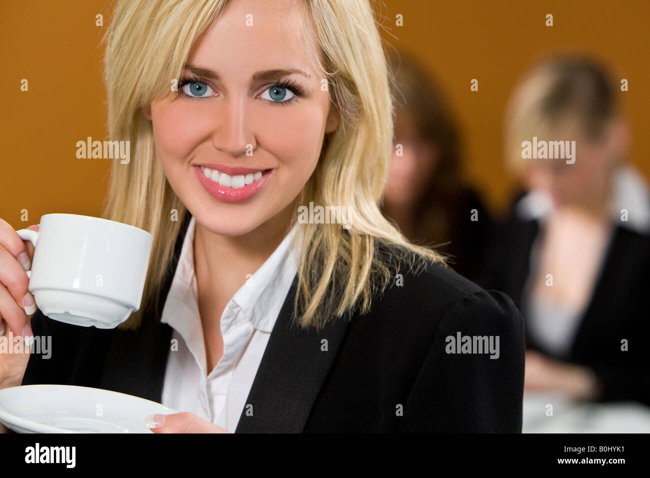 An attractive young female executive takes a coffee break while her ...