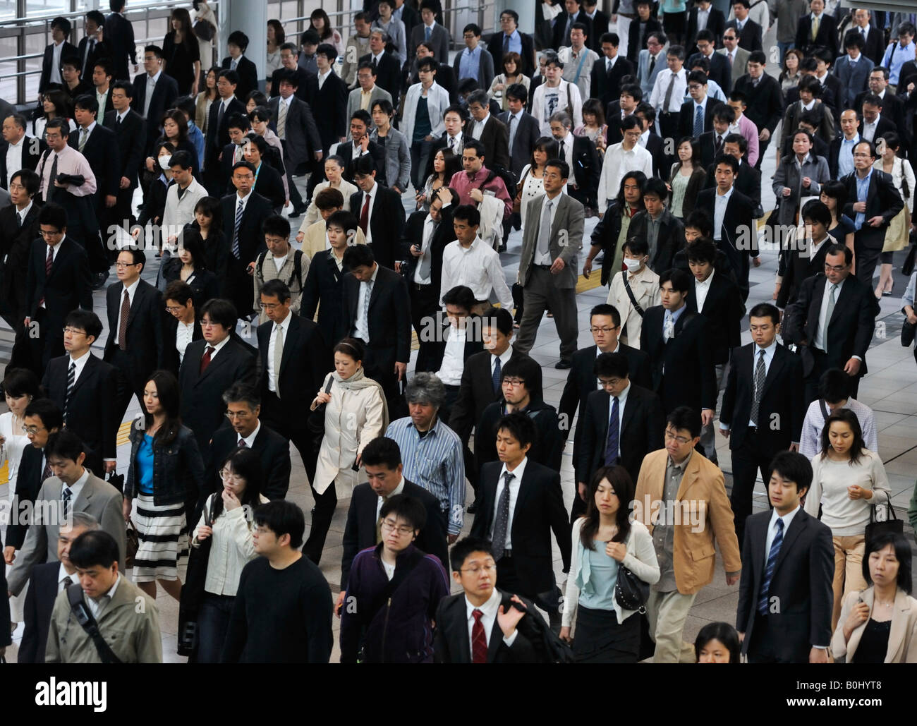 Crowd of commuters walking to work during morning rush hour in railway ...