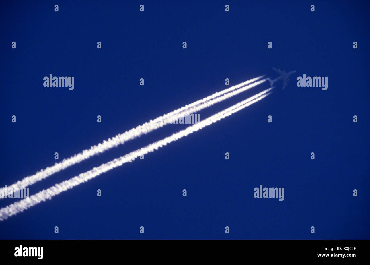 Airplane with vapour trails Stock Photo - Alamy