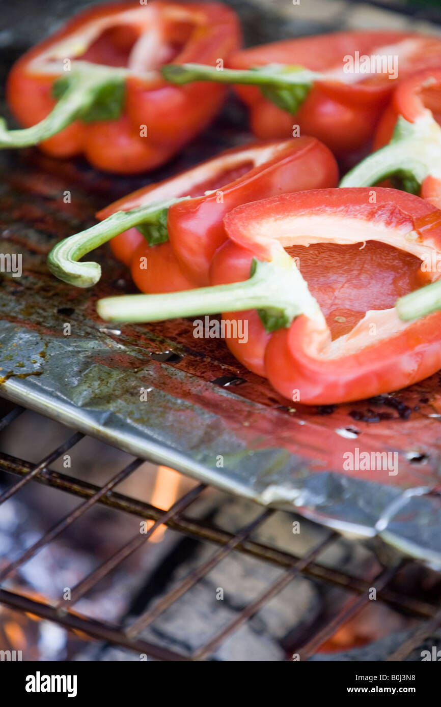 Red bell peppers cooking on the barbecue Stock Photo - Alamy