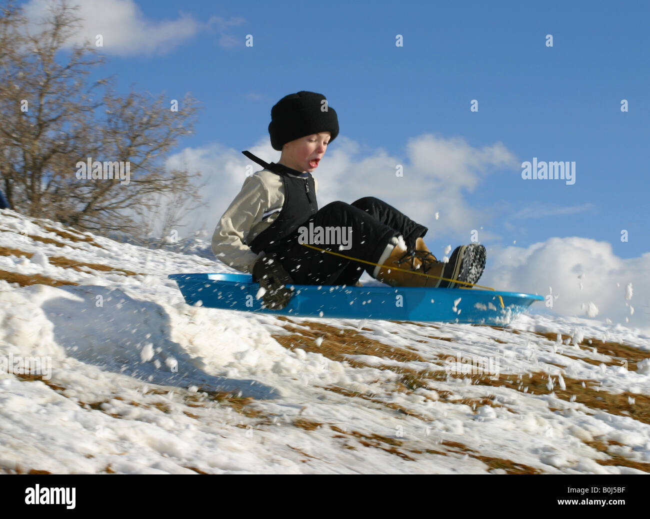 boy riding sled going off jump very fast Stock Photo - Alamy