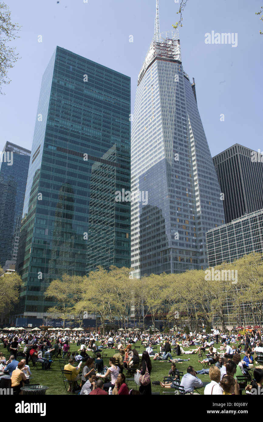 People enjoying the warm spring weather at Bryant Park behind the NY ...