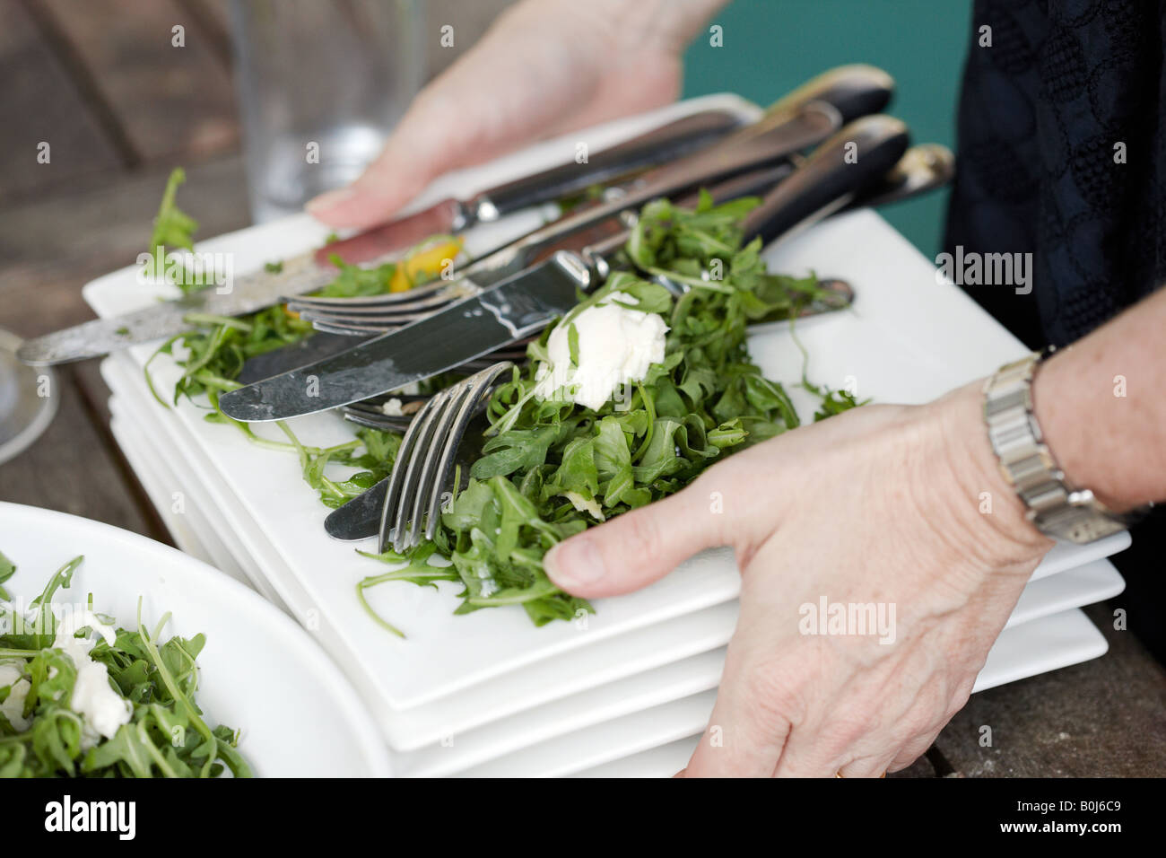Square dinner plates, being cleared from picnic table Stock Photo - Alamy
