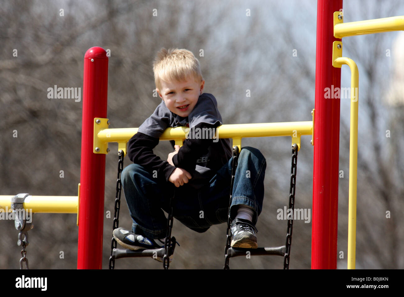 Four year old boy playing on playground equipment Stock Photo - Alamy