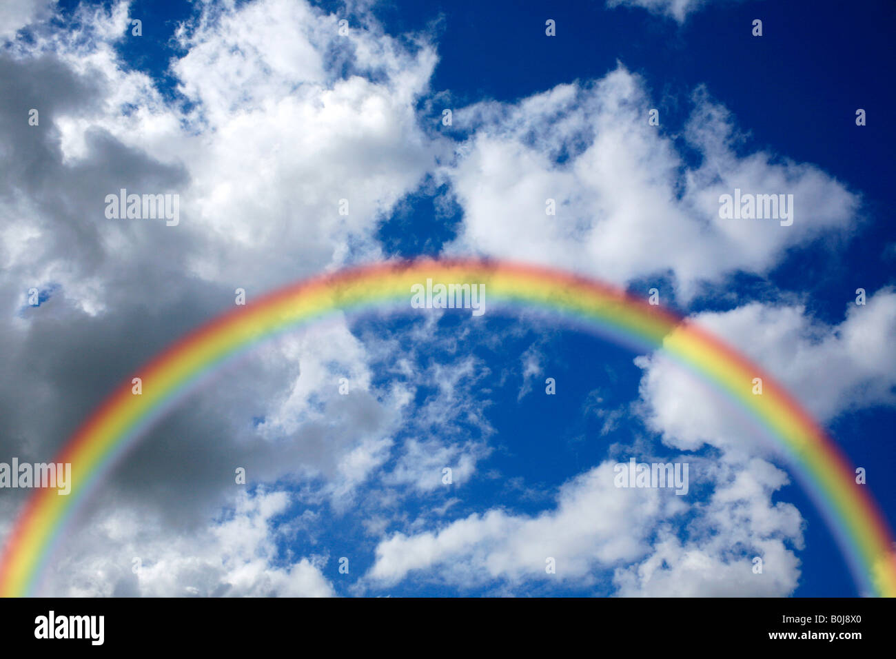 Rainbow in the bright blue summers sky Stock Photo - Alamy
