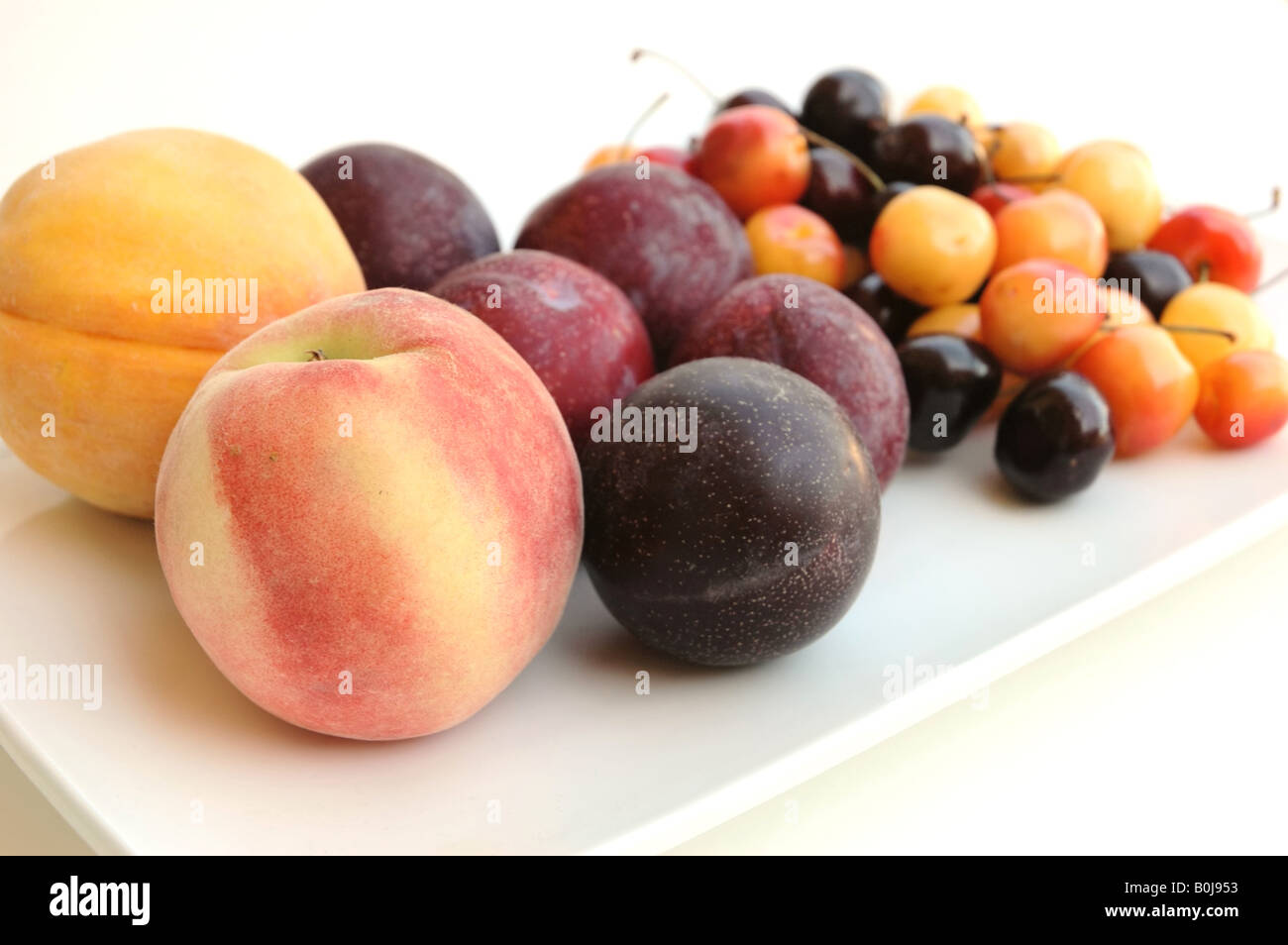 Platter of fresh summer fruit peaches cherries plums Stock Photo - Alamy