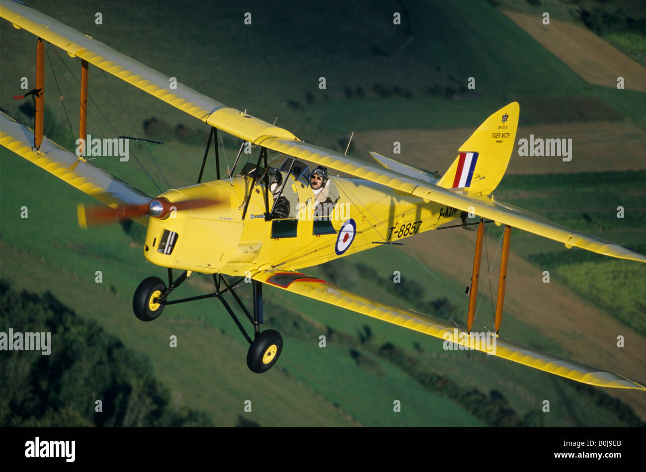 Old British trainer biplane De Havilland DH-82c Tiger Moth in flight ...