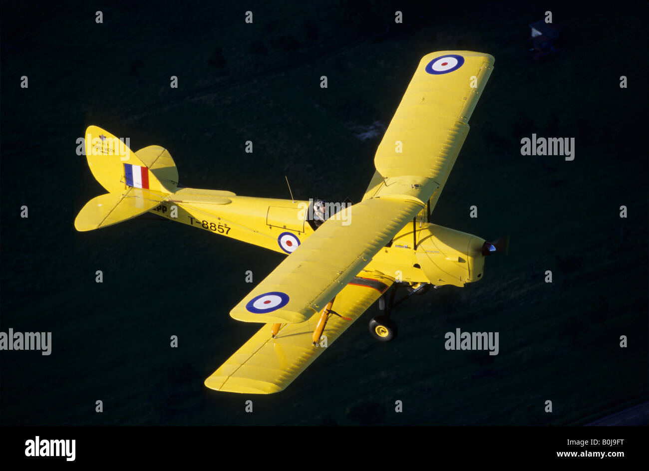 Old British trainer biplane De Havilland DH-82c Tiger Moth in flight ...