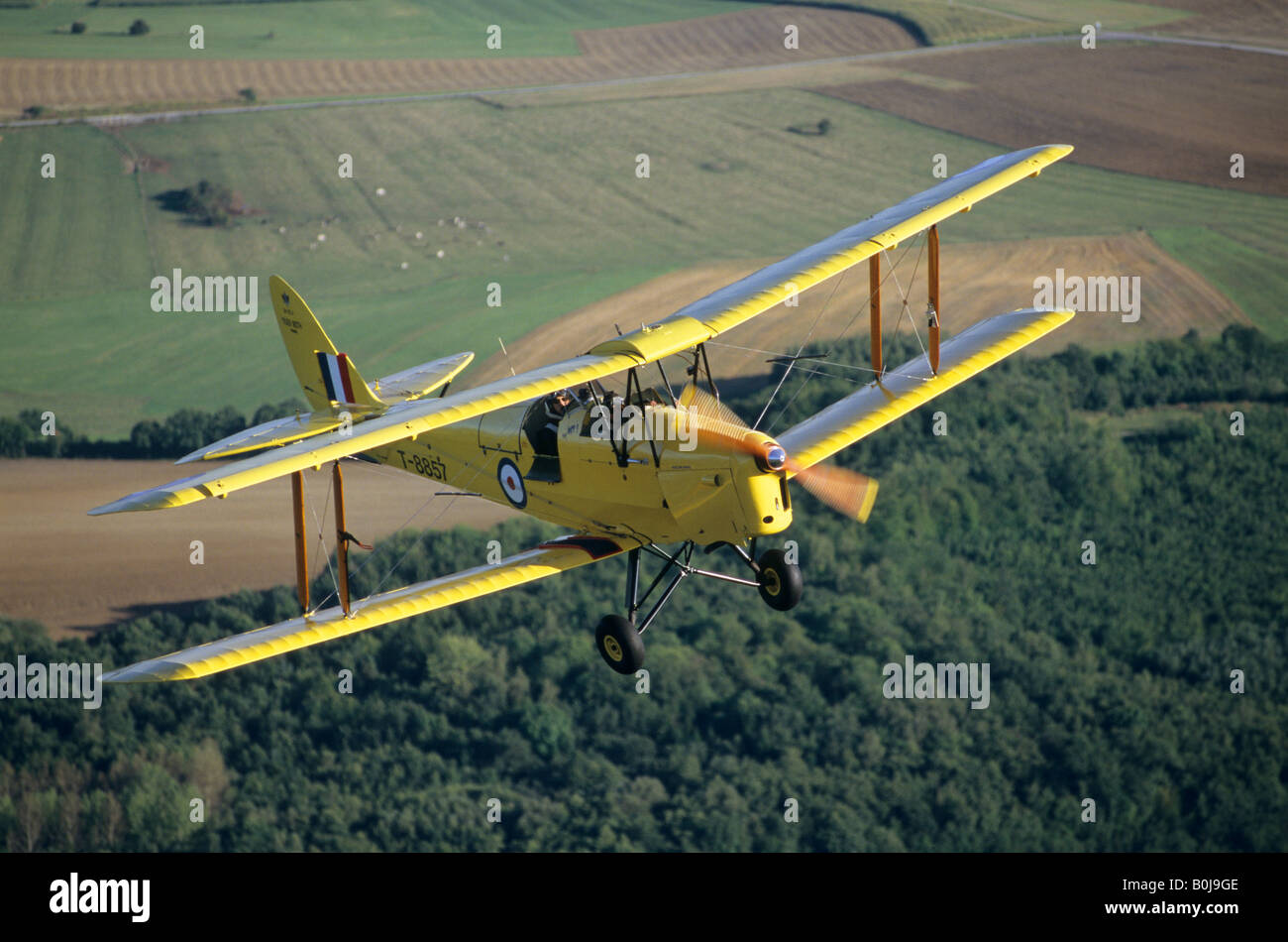 Old British trainer biplane De Havilland DH-82c Tiger Moth in flight ...