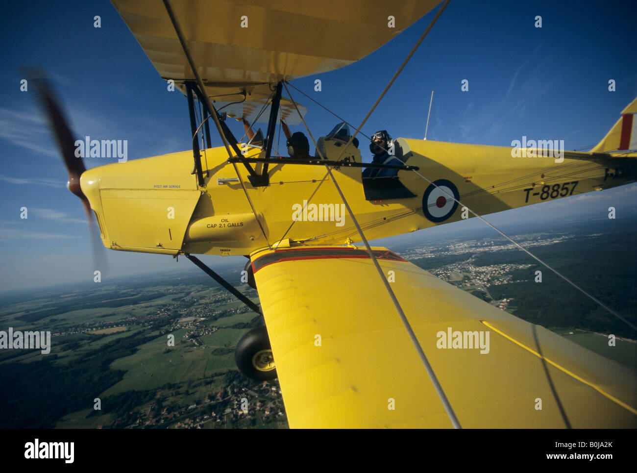 Old British trainer biplane De Havilland DH-82c Tiger Moth in flight ...