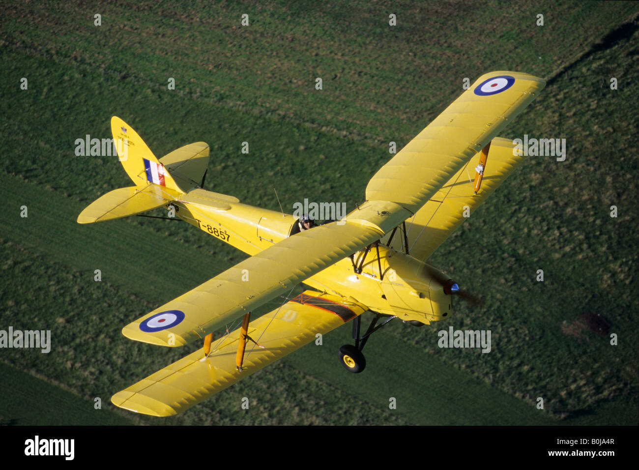 Old British trainer biplane De Havilland DH-82c Tiger Moth in flight ...