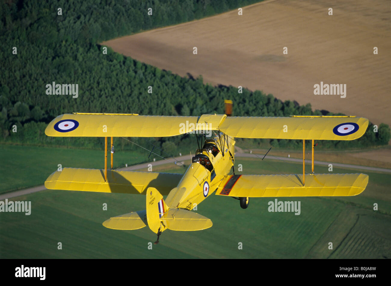 Old British trainer biplane De Havilland DH-82c Tiger Moth in flight ...