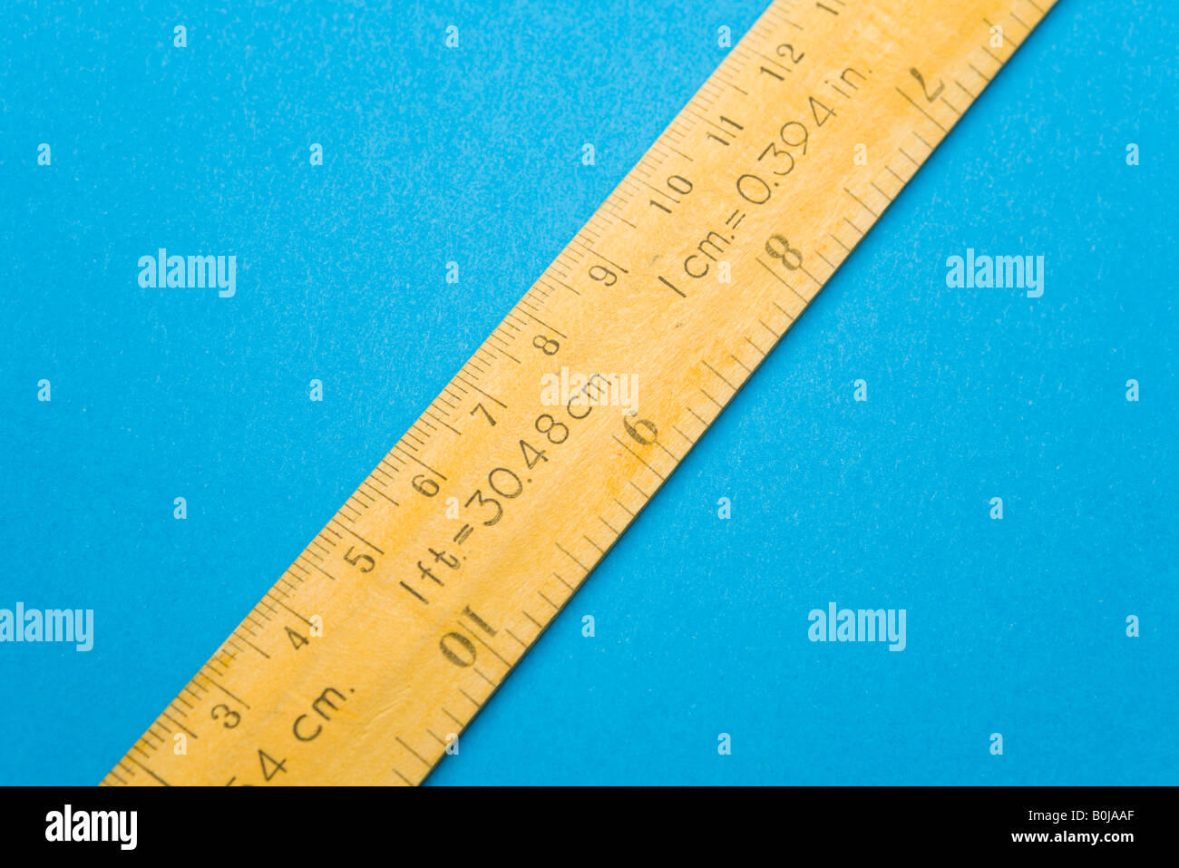 Yellow wooden ruler on blue background Stock Photo - Alamy