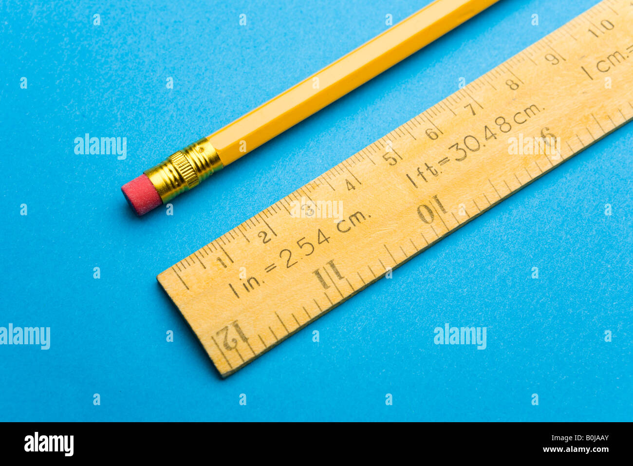 Wooden ruler and pencil laying on blue background Stock Photo - Alamy