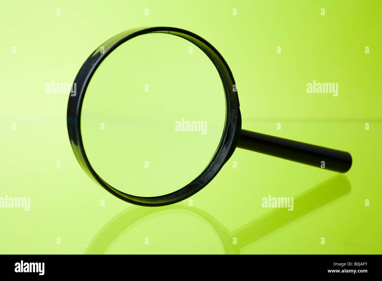 Magnifying glass on green background Stock Photo - Alamy