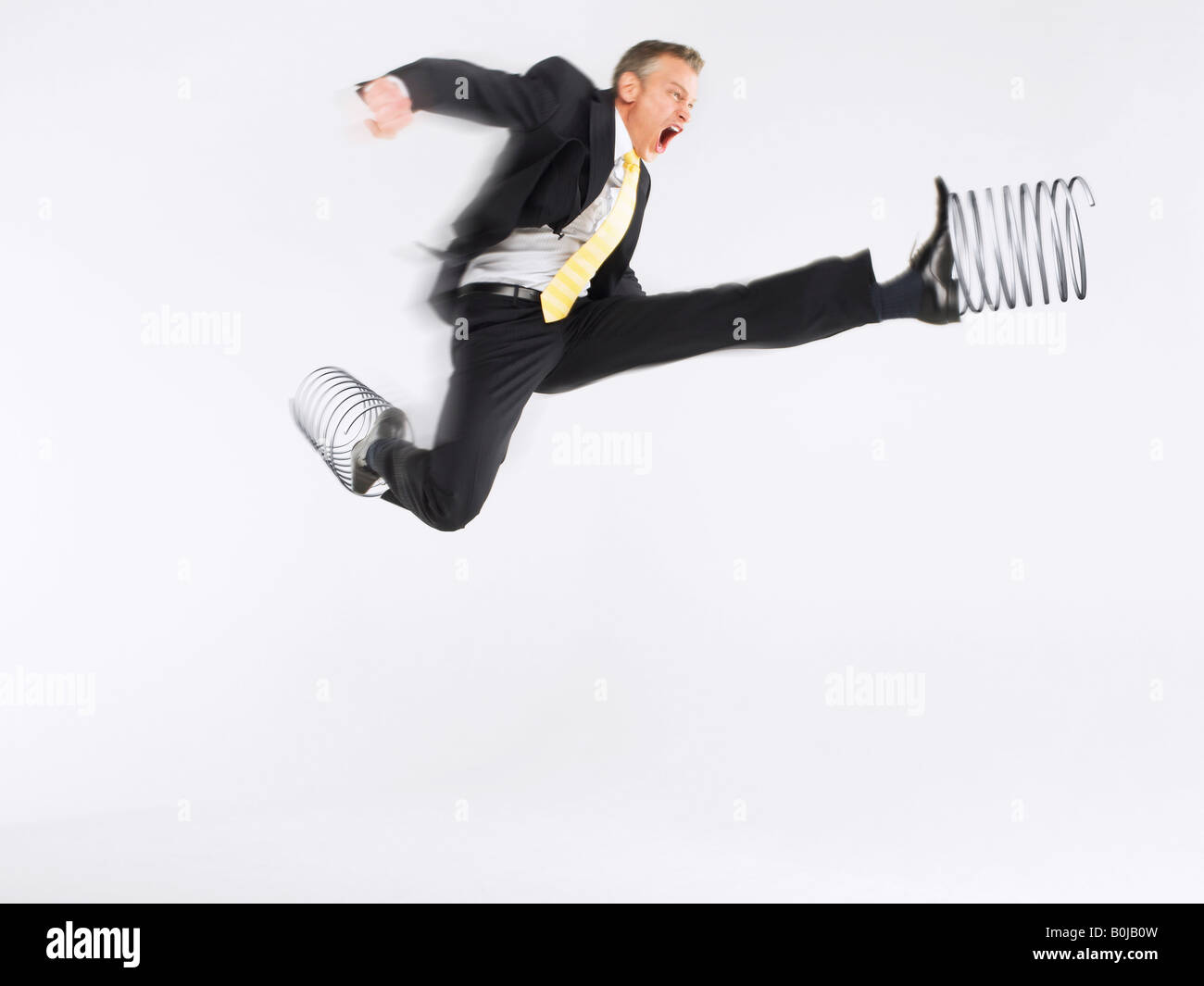 Business man jumping with springs on feet Stock Photo - Alamy