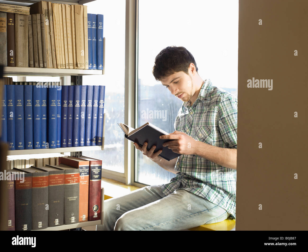 College Student Reading in Library Stock Photo - Alamy