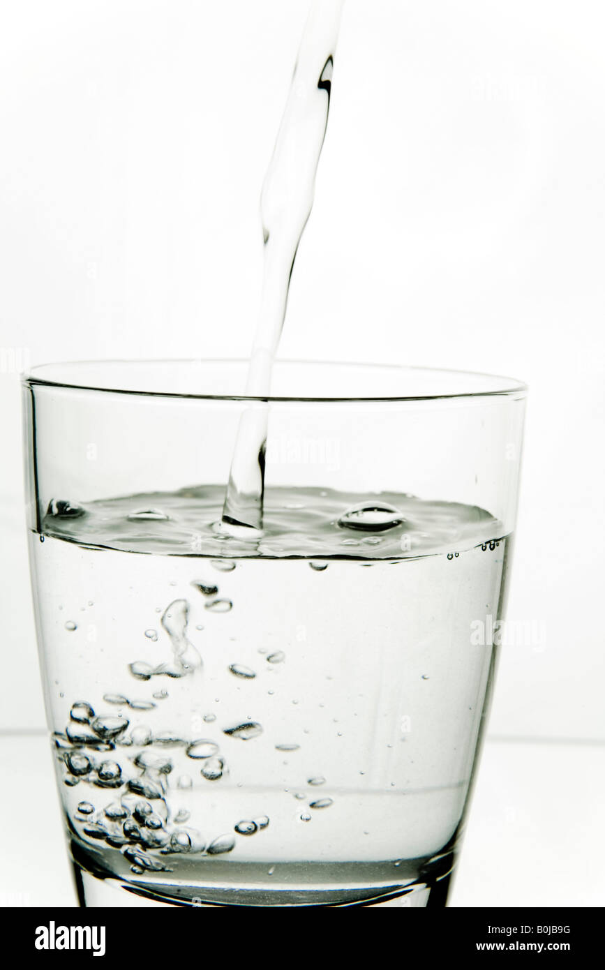 Pouring water to a clear glass Stock Photo - Alamy