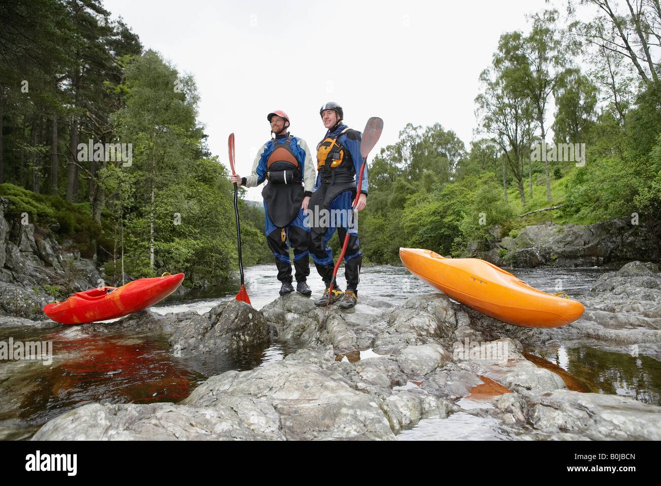 Two men with kayaks by river Stock Photo - Alamy