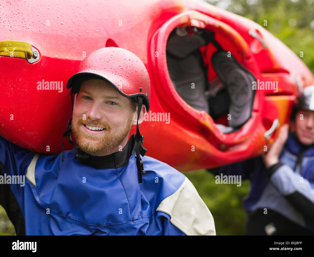 Two men carrying kayak, outdoors, portrait Stock Photo - Alamy