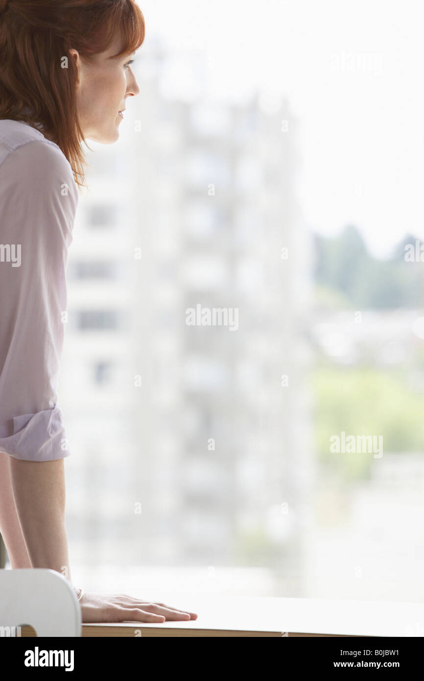 Woman looking out of window Stock Photo - Alamy