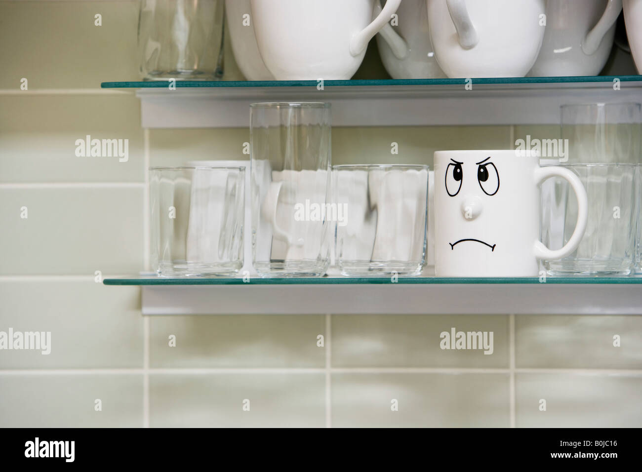 Sad face mug on kitchen shelf Stock Photo - Alamy