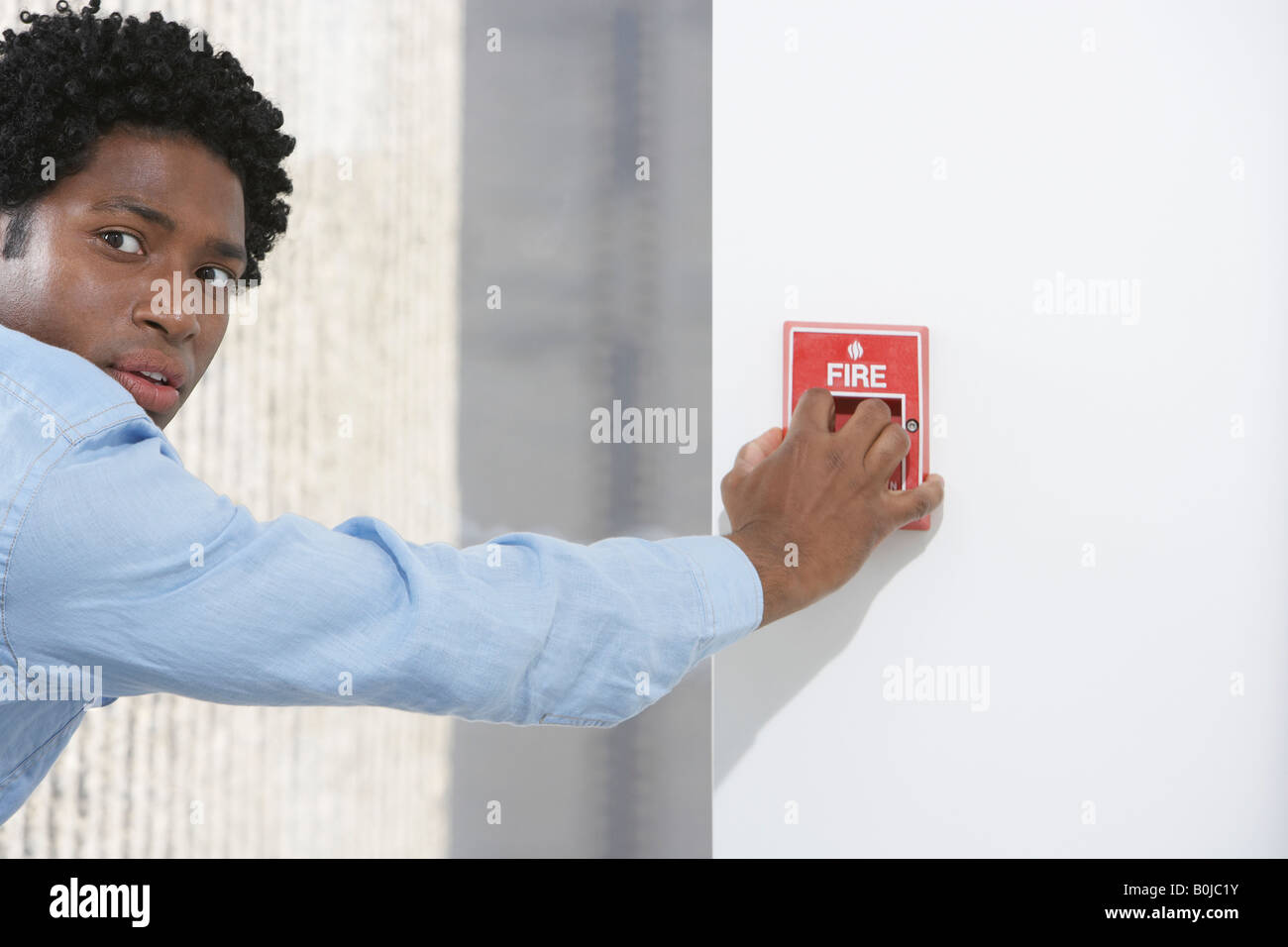 Man starting fire alarm, indoors Stock Photo - Alamy