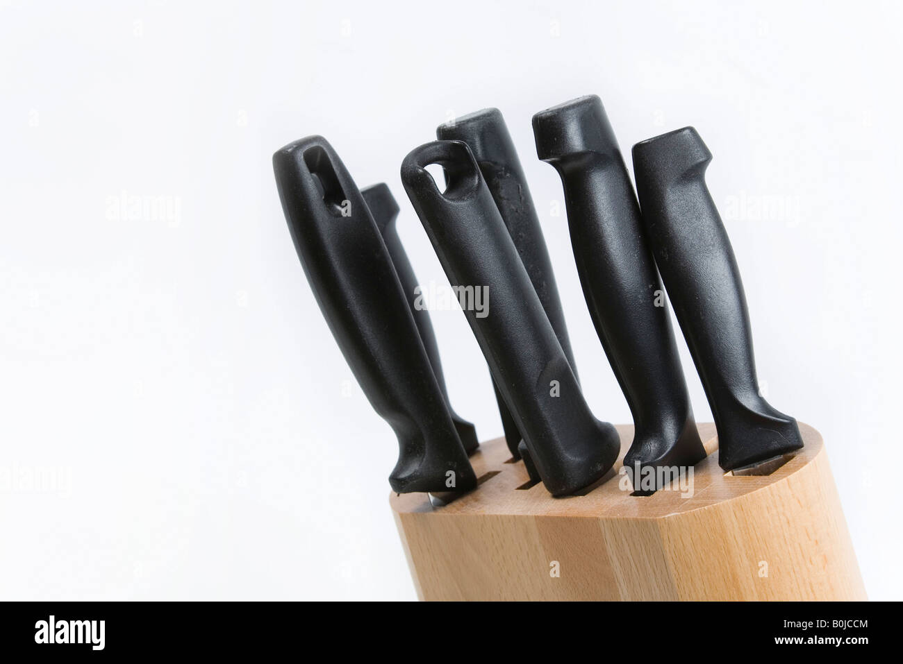 Kitchen knives in a wooden block on a white background Stock Photo - Alamy