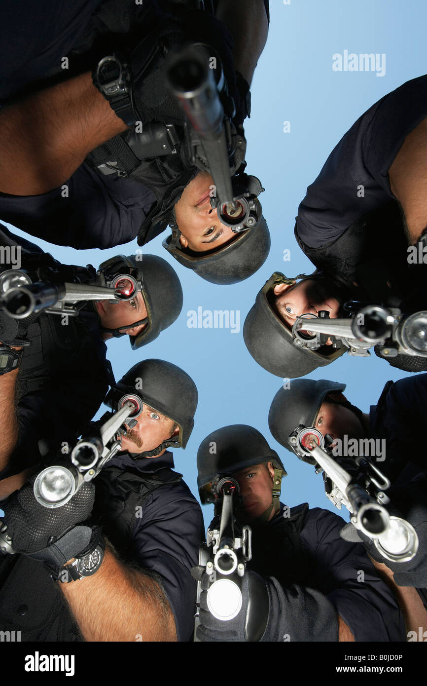 Group portrait of Swat officers standing in circle, aiming guns Stock Photo - Alamy