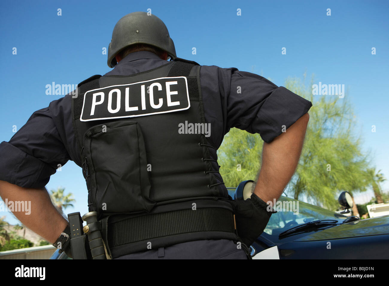 Police officer in bulletproof vest outdoors, back view Stock Photo - Alamy