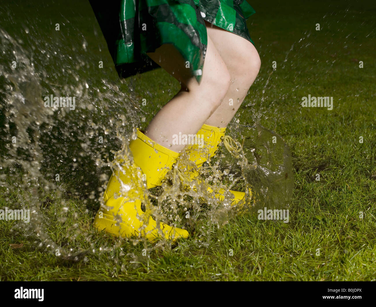 Woman jumping in rain puddle Stock Photo - Alamy