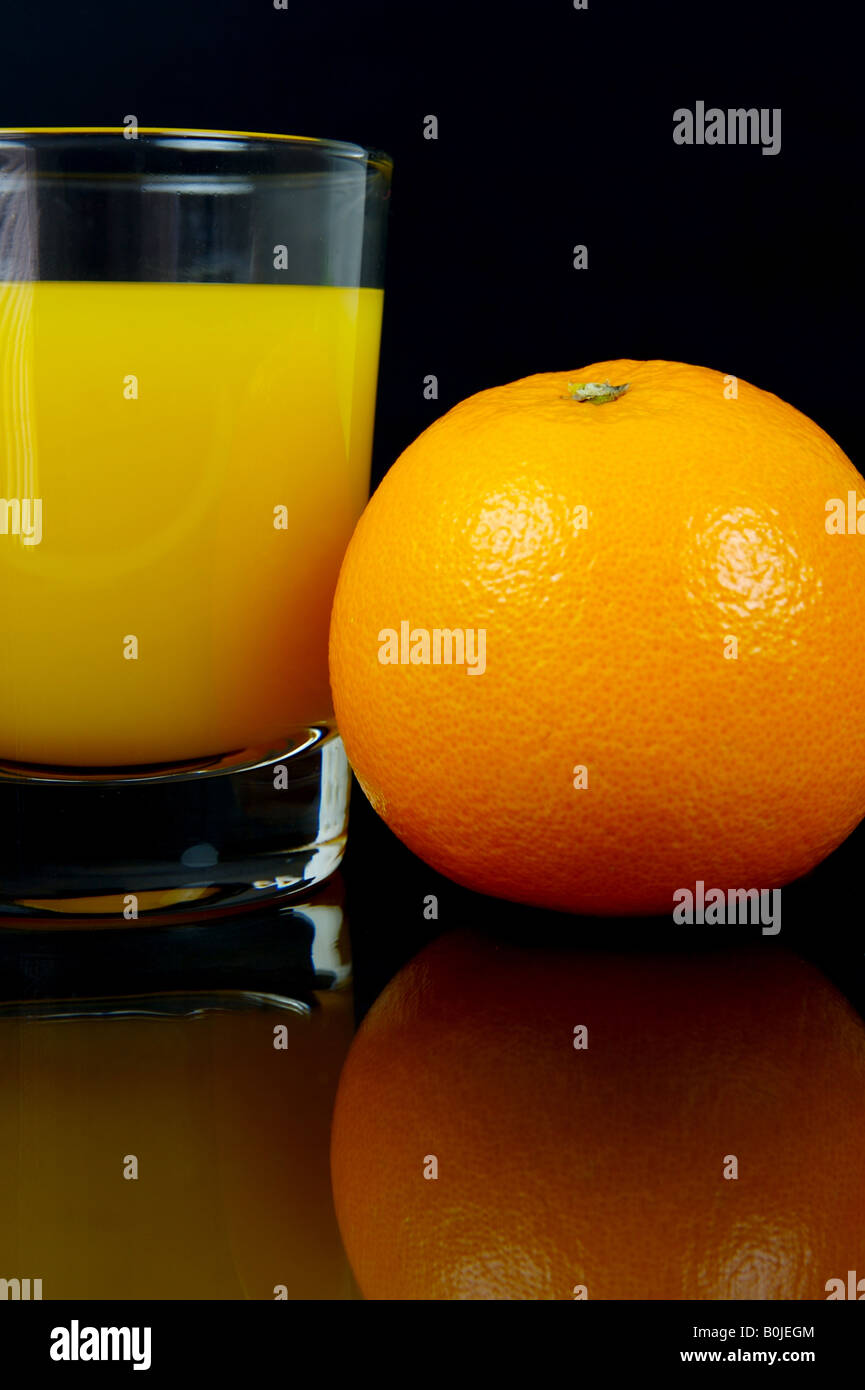 Orange juice isolated against a black background Stock Photo - Alamy