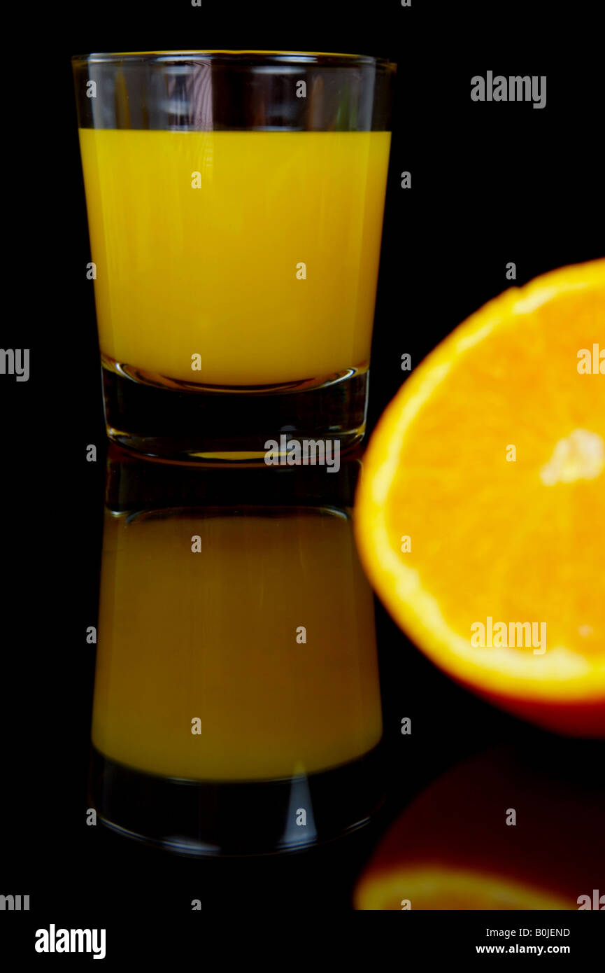 Orange juice isolated against a black background Stock Photo - Alamy
